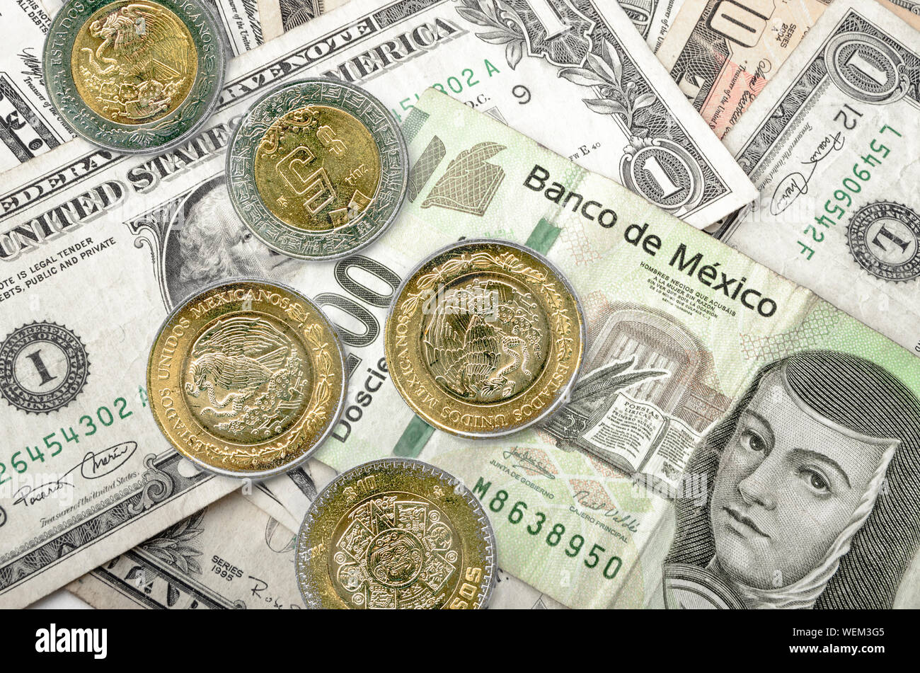 Mexican Peso Coins over assorted Dollars and Mexican Peso bills cash ...