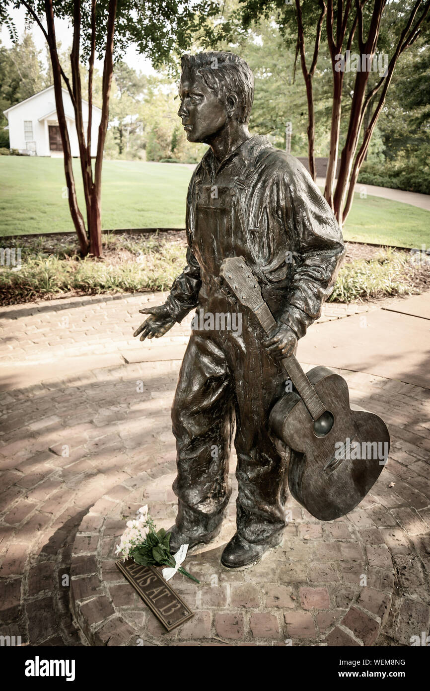 A bronze statue of 13 year old Elvis with guitar stands on the pathway ...