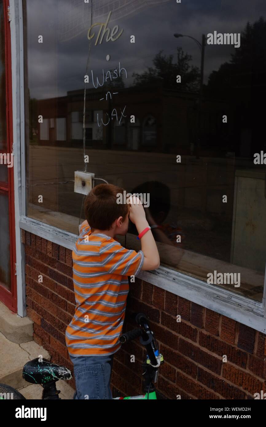 Boy looking into store window hi-res stock photography and images - Alamy