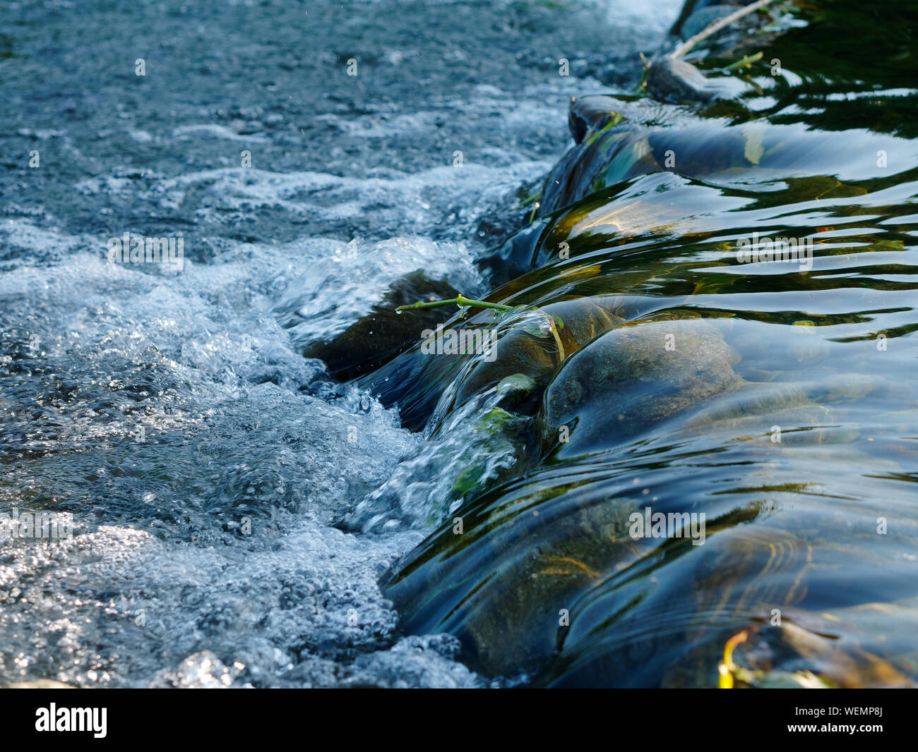 Close-up of water flowing through river rocks Stock Photo - Alamy