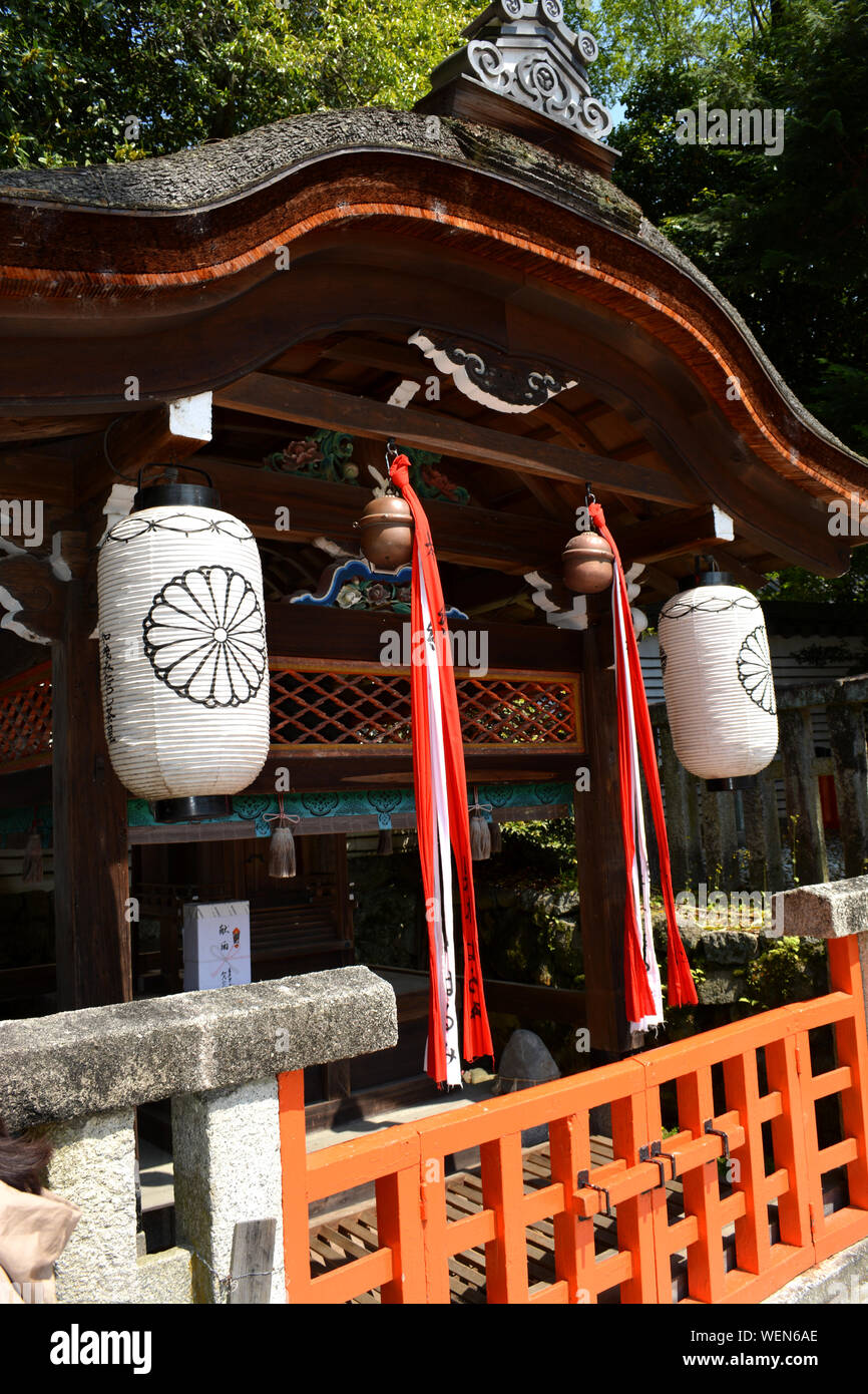 Japanese shrine with lanterns, traditional roof, bells, and stone work ...