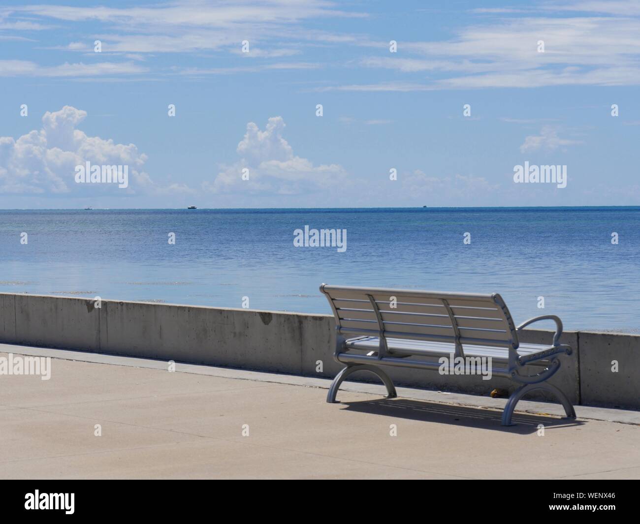 Medium close up of a bench facing the ocean along S Roosevelt Boulevard ...
