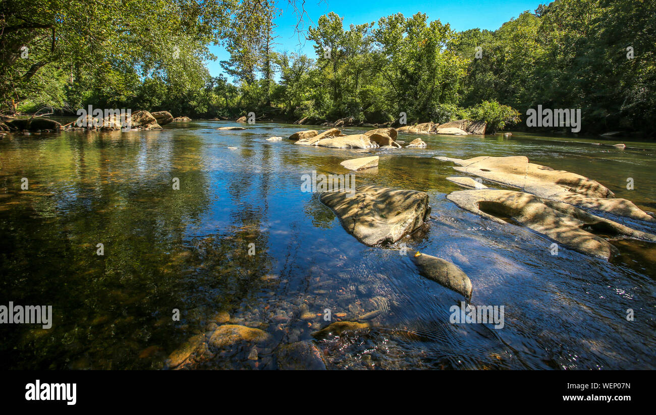 Mountain Hiwassee River flowing through the green forest . Brasstown NC ...