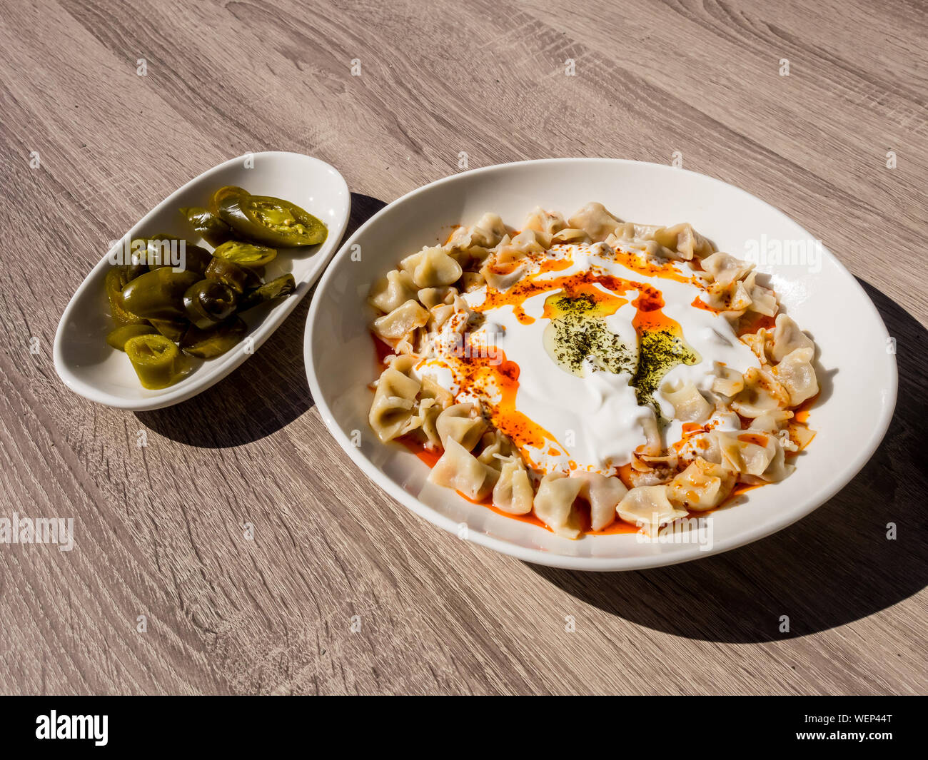 Turkish Manti with green hot pickled peppers, tomato sauce, yogurt and ...