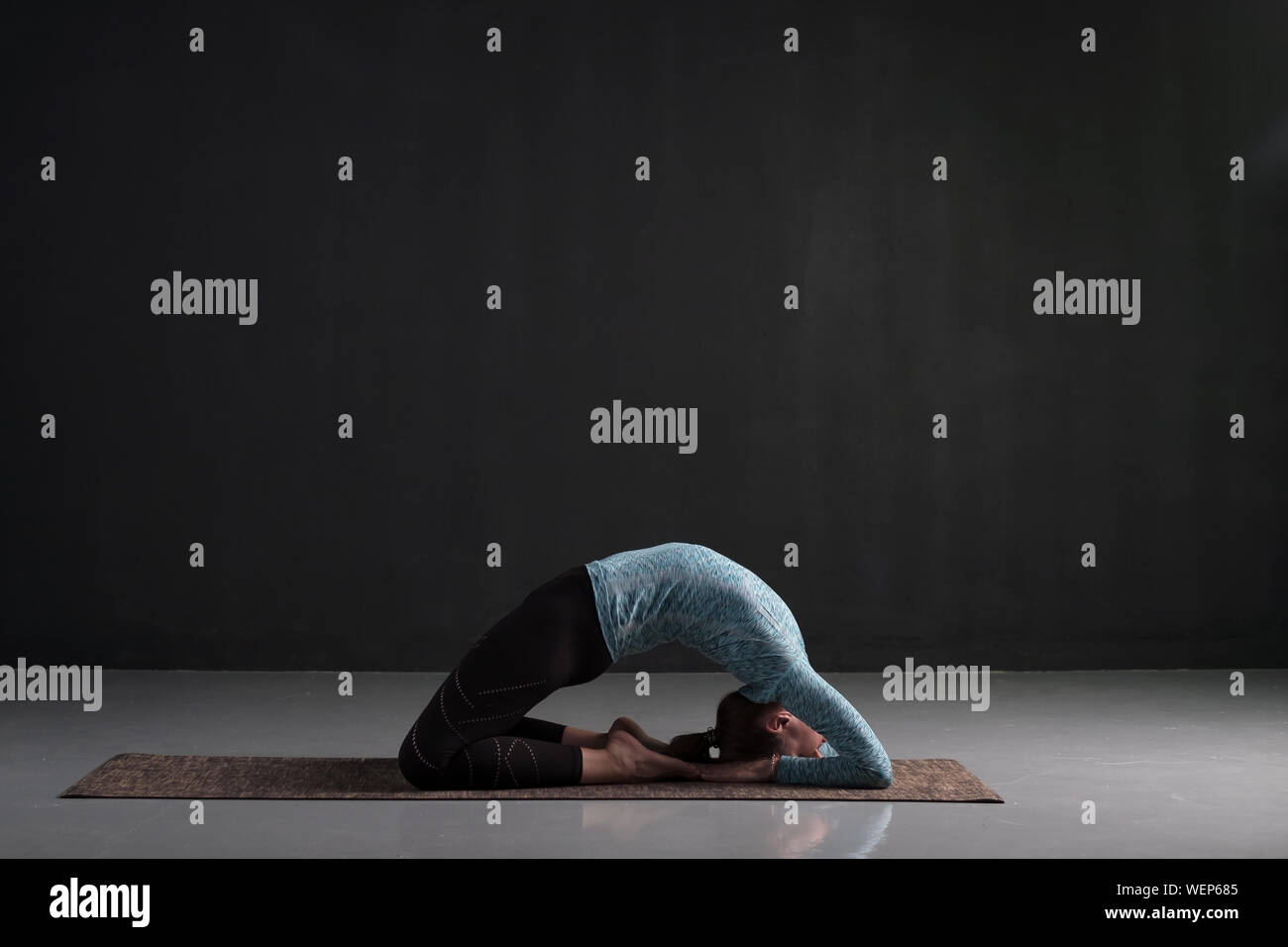 Sporty slim yogini woman practices yoga asana Kapotasana or pigeon pose ...