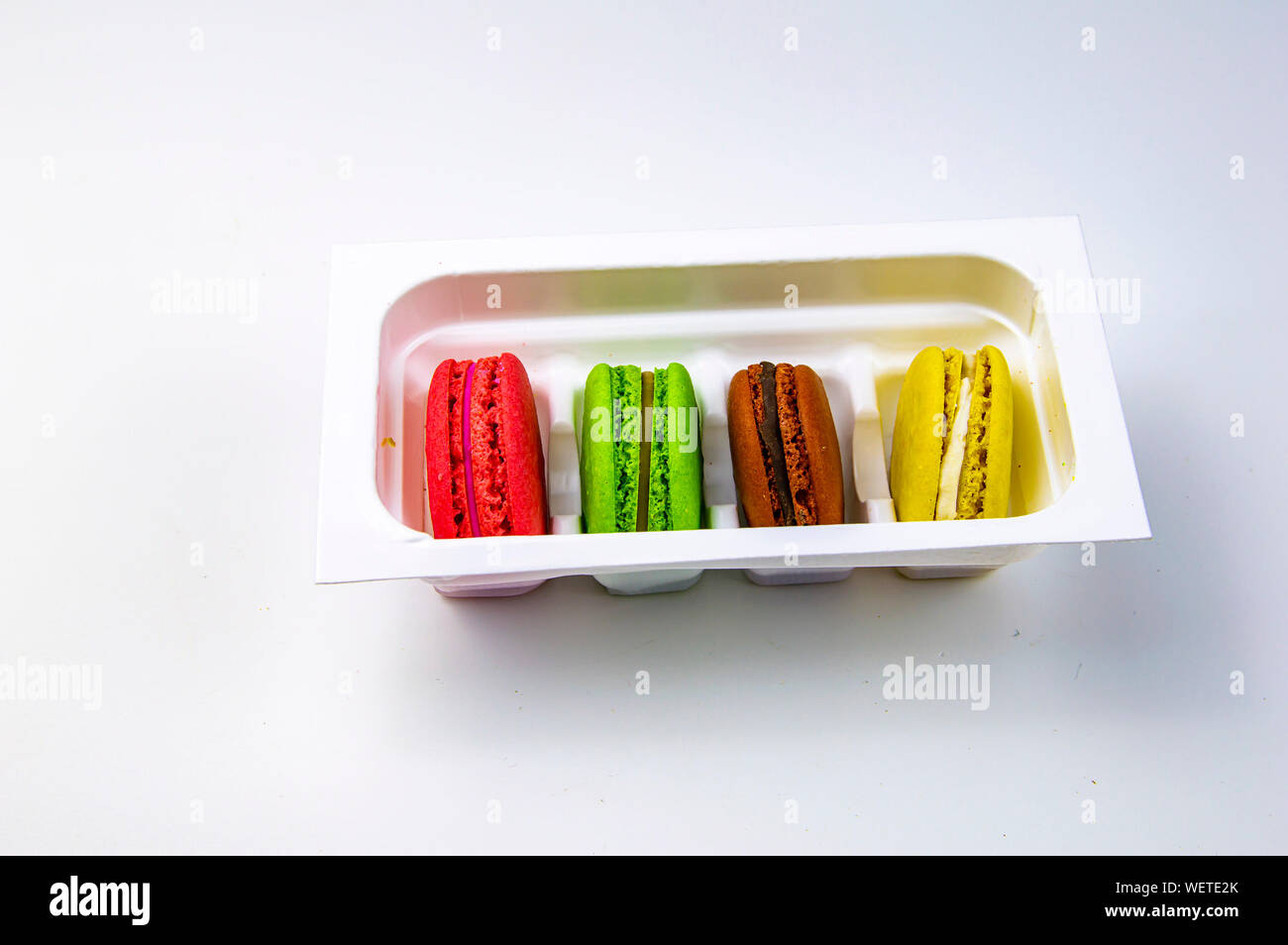 Round colored cookies in the package on a white background. Dessert ...