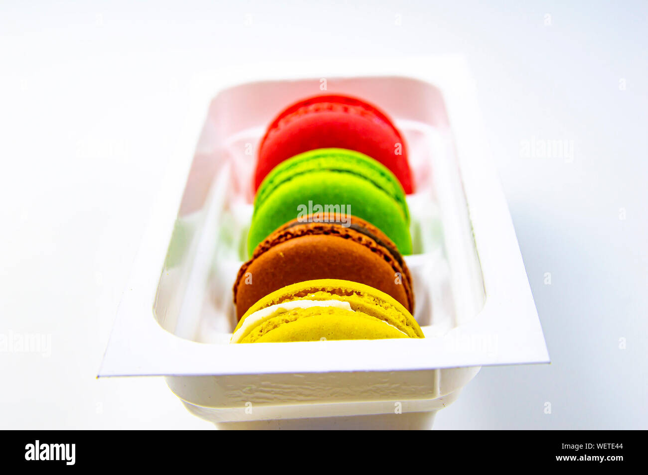 Round colored cookies in the package on a white background. Dessert ...