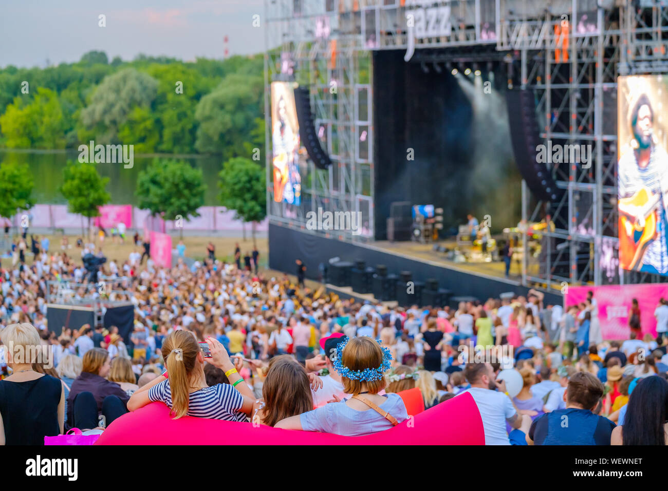 Friends watching concert at open air music festival, back view, stage ...