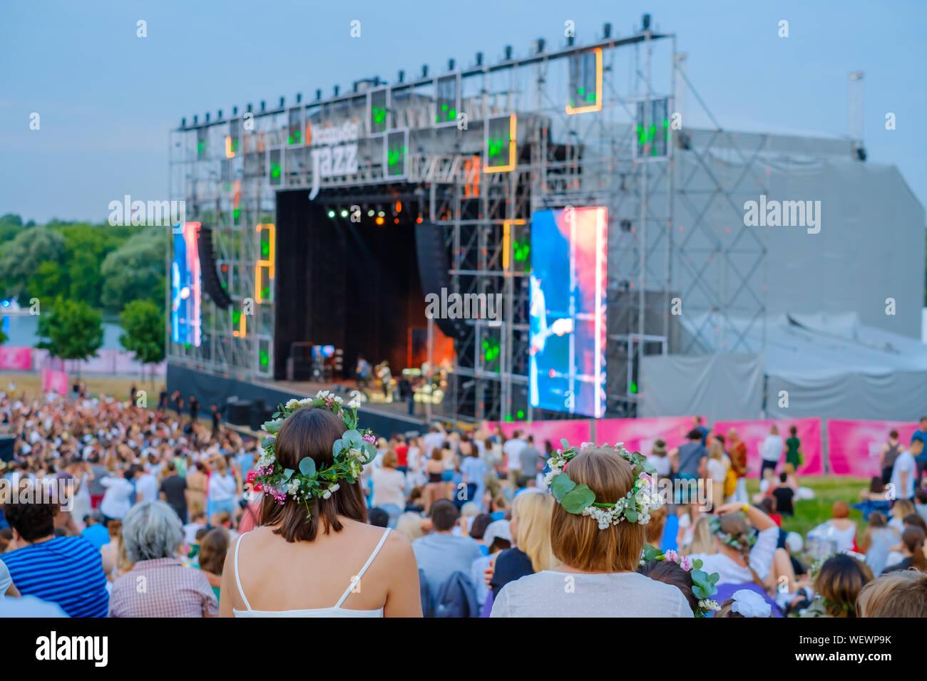 Friends watching concert at open air music festival, back view, stage ...