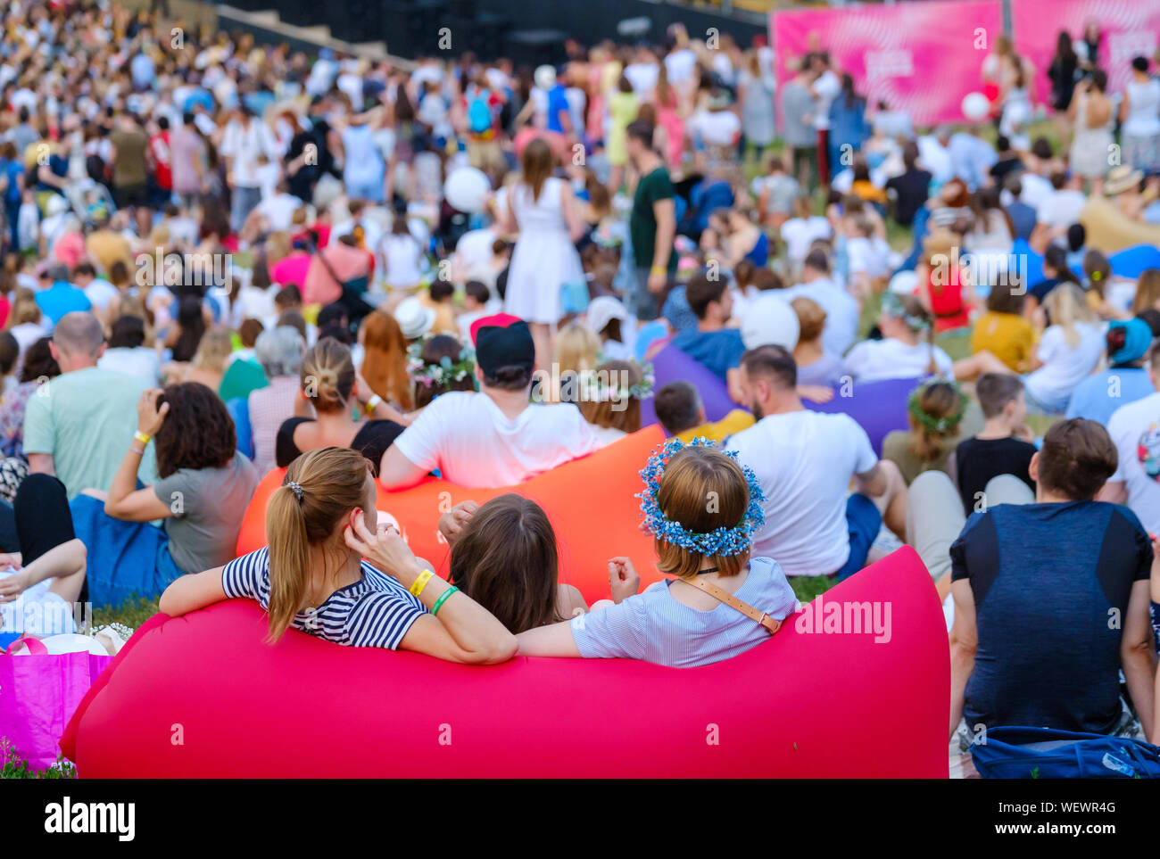 Friends watching concert at open air music festival, back view, stage ...