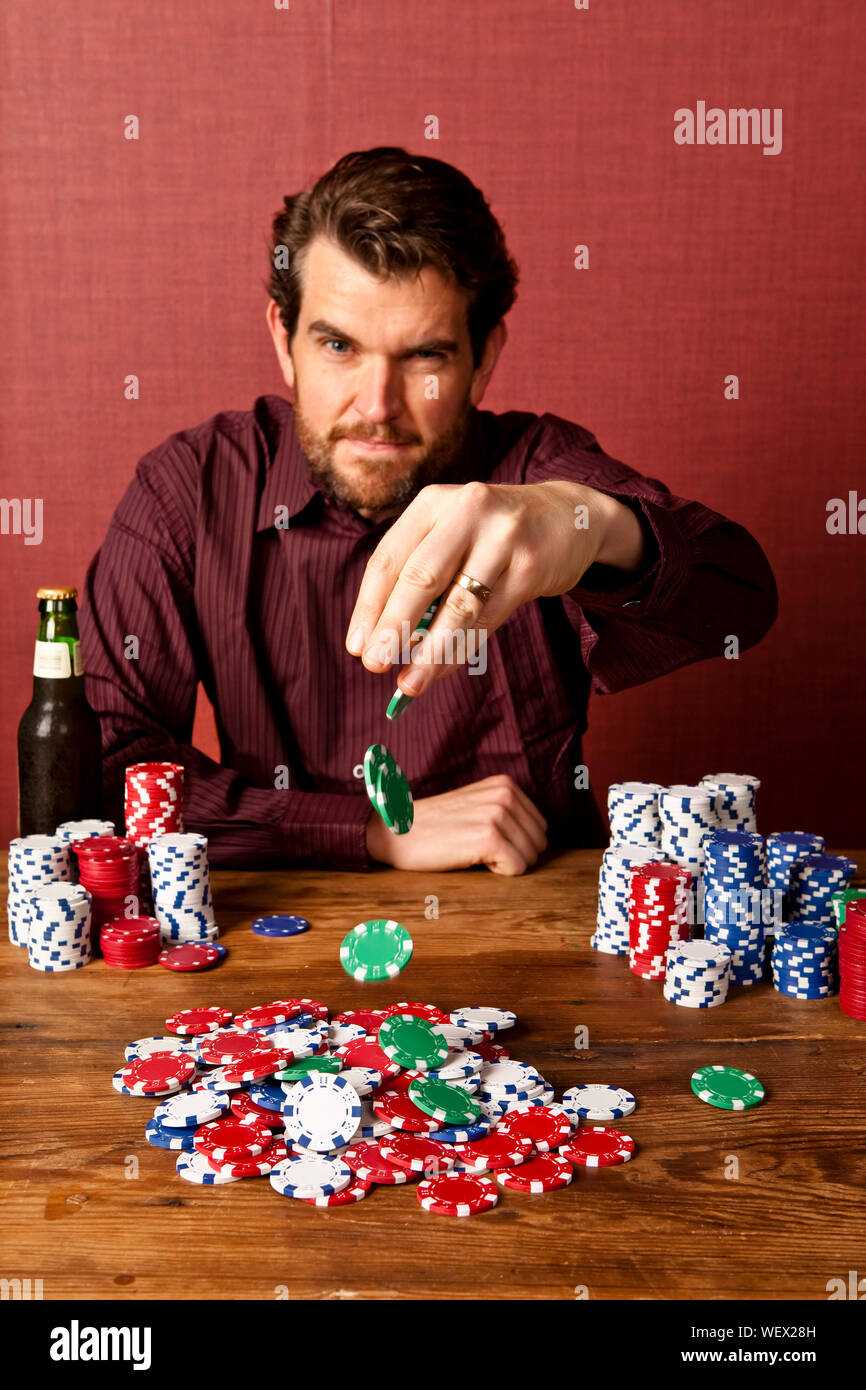 man dropping poker chips on to pile for a bet, focus on chips Stock ...