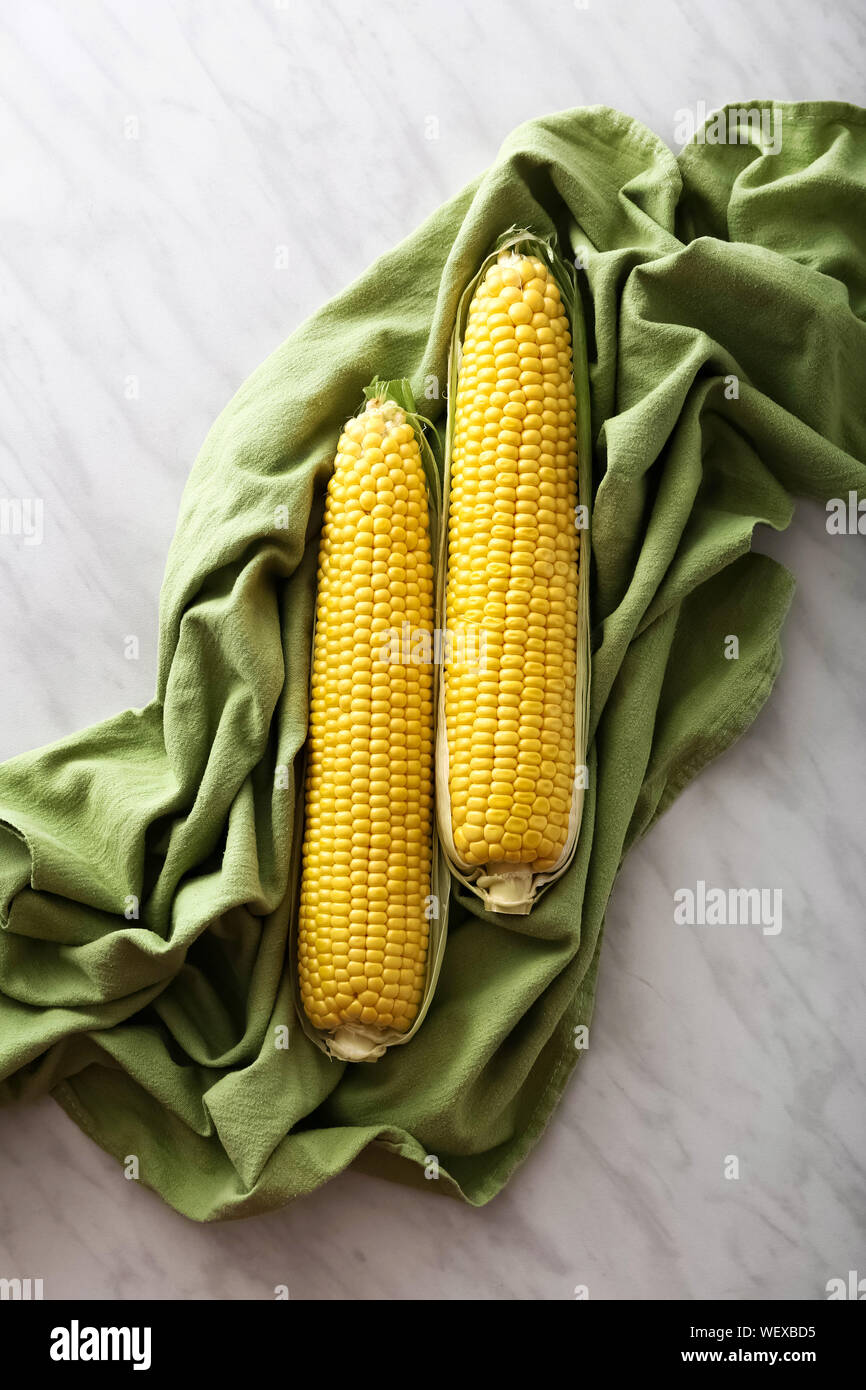 Ripe, sweet, fresh corn on cobs. Top view on a marble table Stock Photo ...