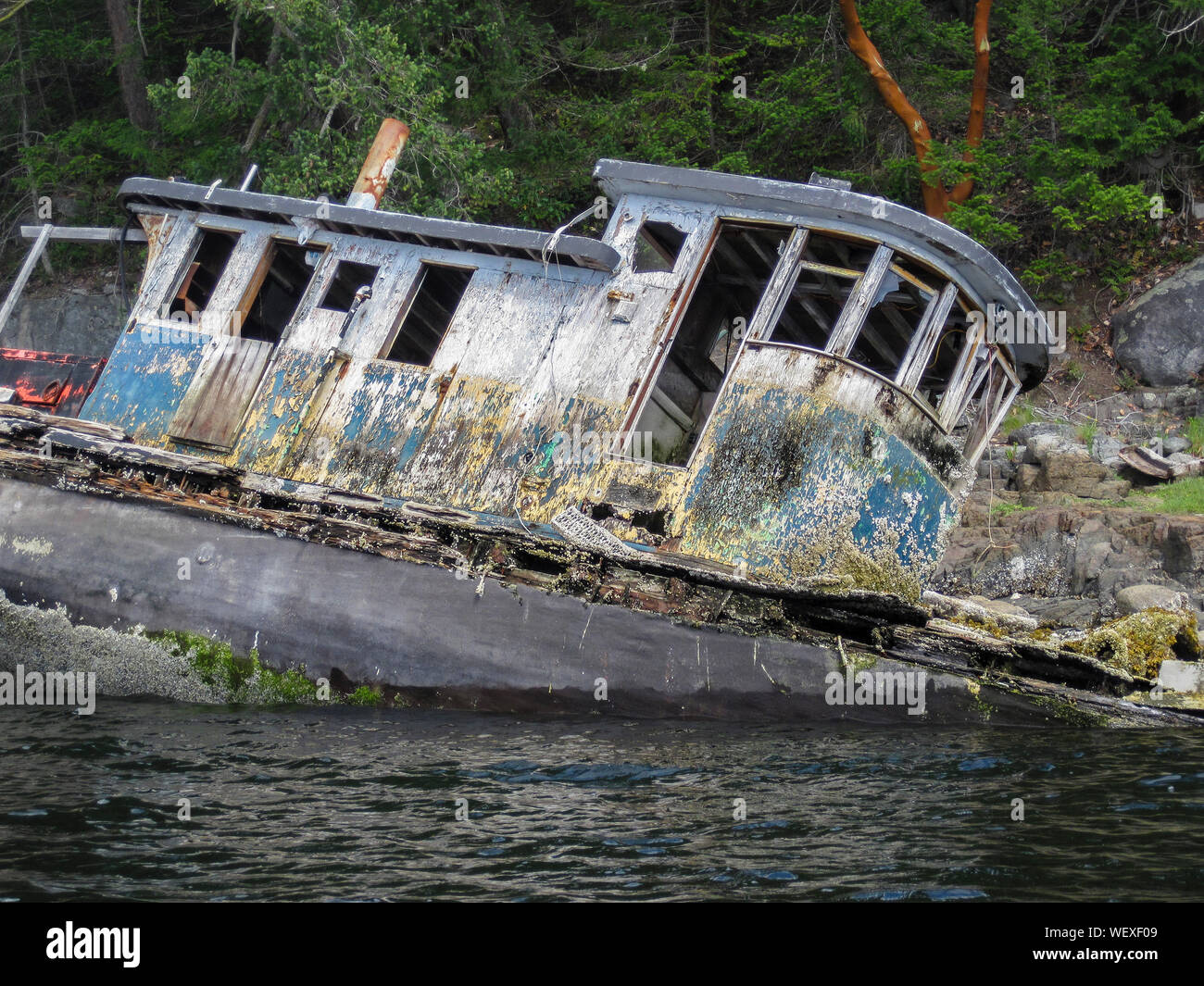 The wreck of an old wooden tugboat, the Kwatna, is heeled over on the ...