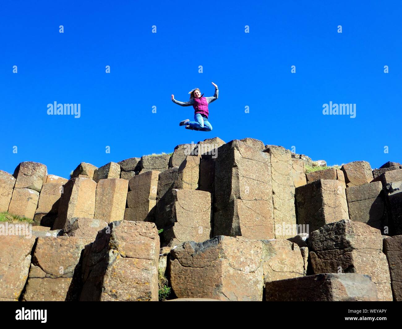 Woman jumping rock formation hi-res stock photography and images - Alamy