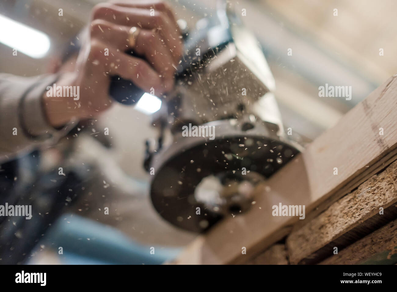 Carpenter using electric woodworking. Routing is a high speed process ...