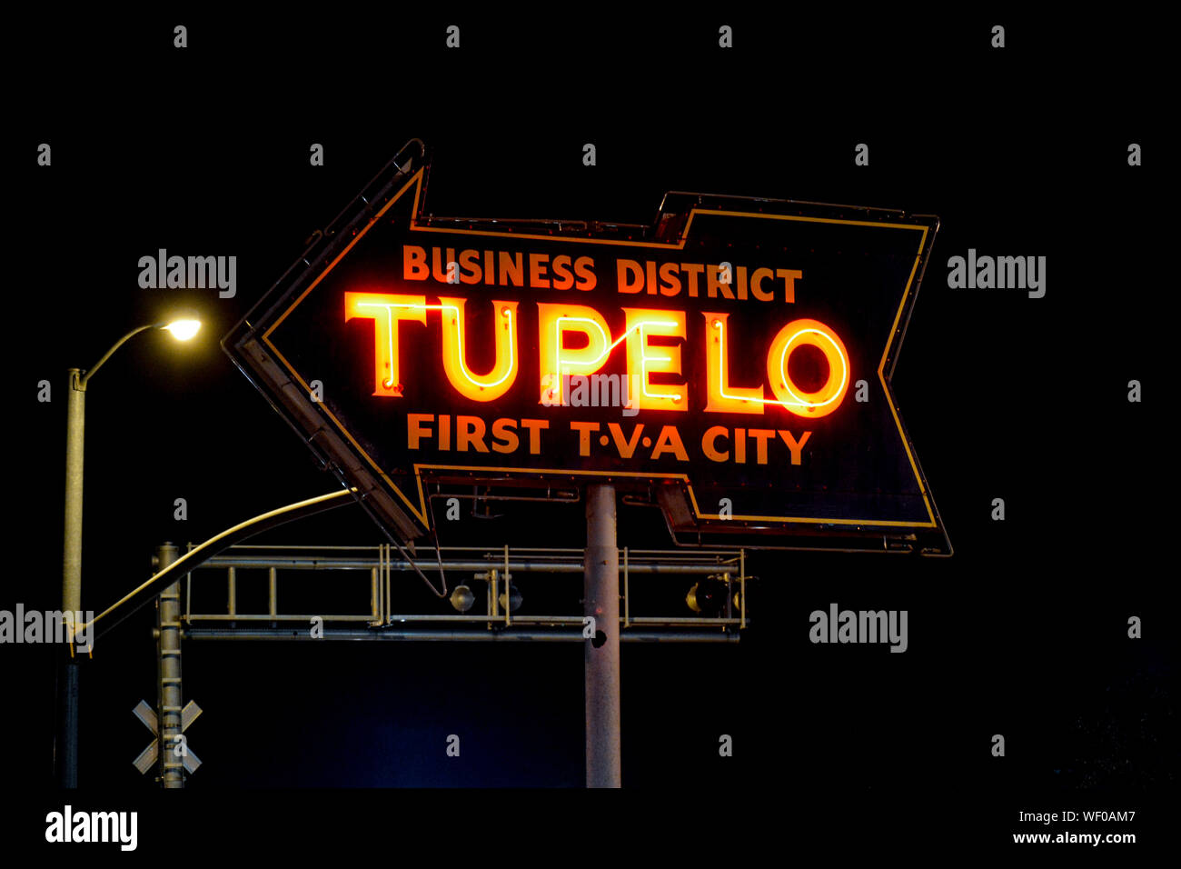 Old neon sign at night with arrow pointing towards the Tupelo business ...