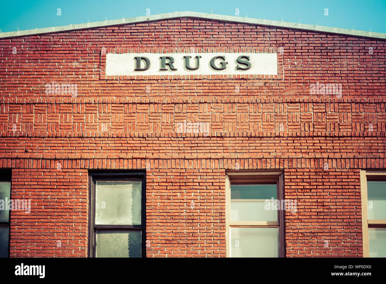 A close-up of signage on a textural vintage brick building reading ...