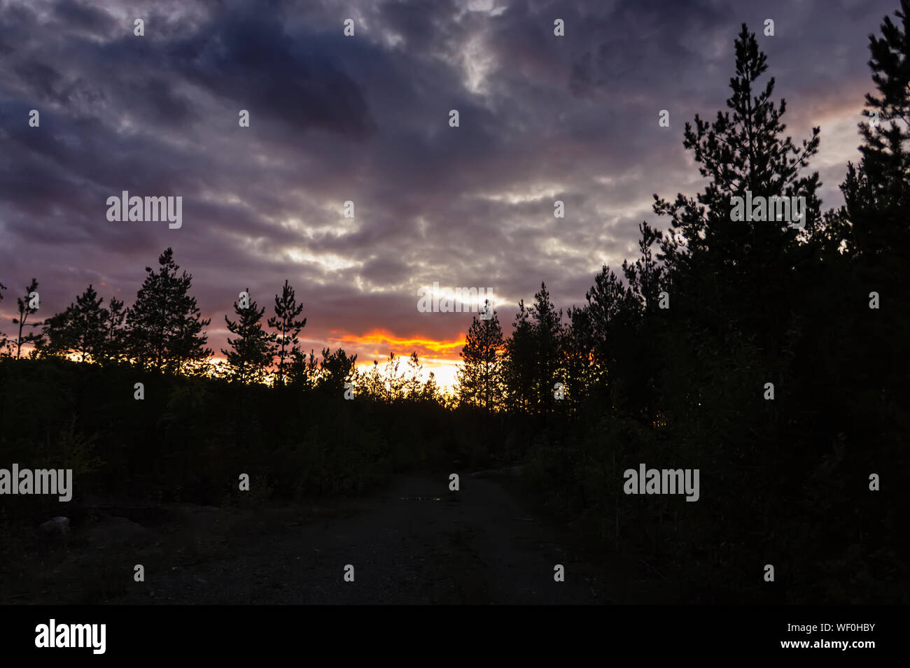 Cumulus sunset clouds with sun setting down. The sky with dark clouds ...