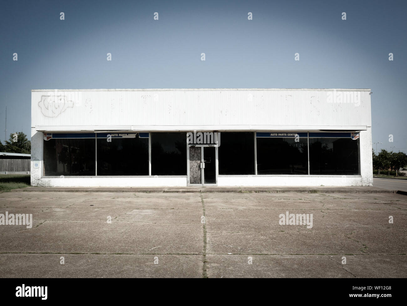 Abandoned old white commercial building in distress, once an Auto Parts ...