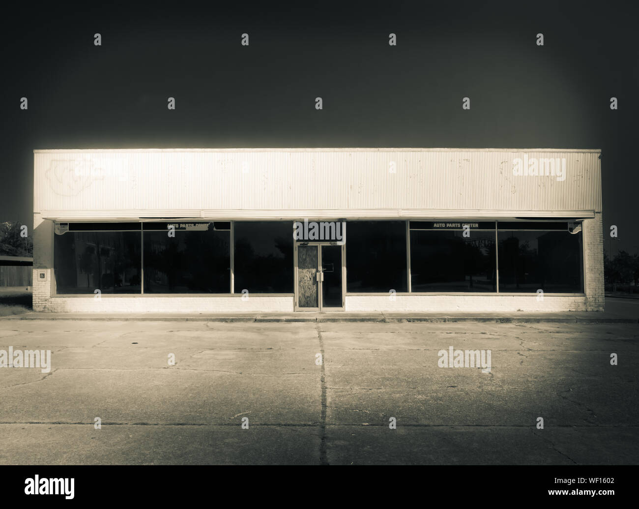 Abandoned old white commercial building in distress, once an Auto Parts ...