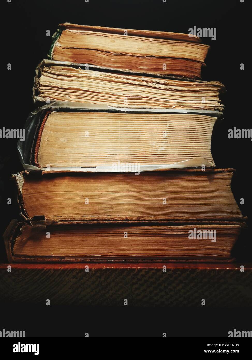 Stack Of Old Books Against Black Background Stock Photo - Alamy