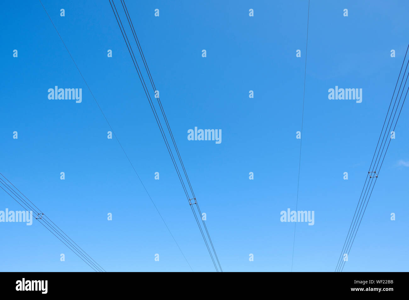 High-Voltage Electricity cables isolated in blue sky Stock Photo - Alamy