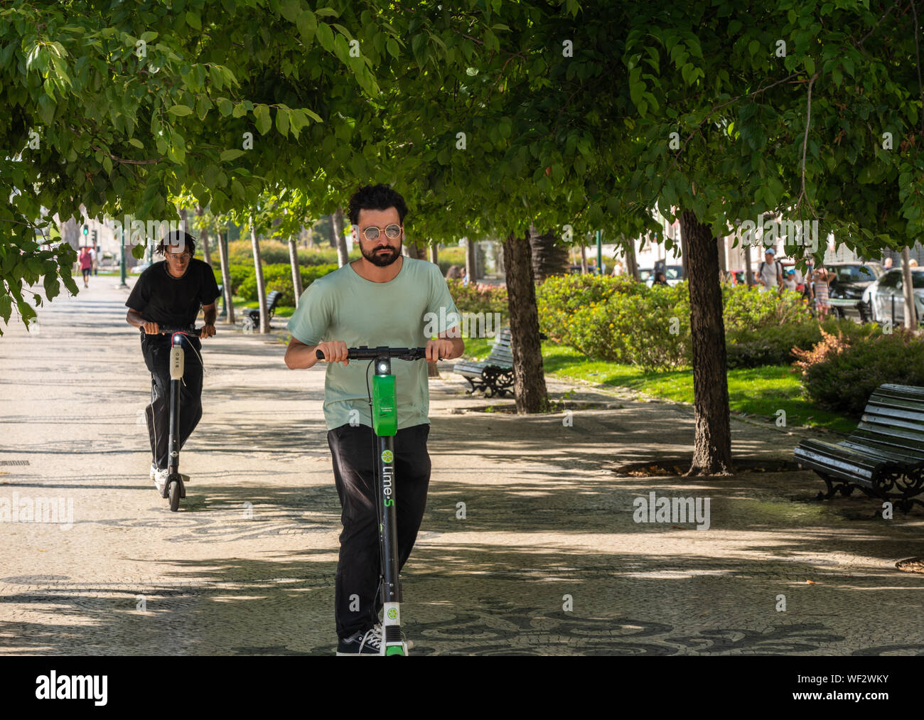 People riding a Lime electric scooter along Liberty Avenue Stock Photo ...