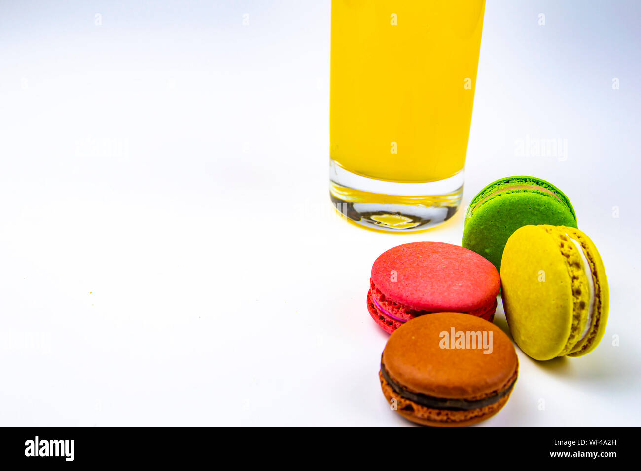 Round color cookies and juice in a glass on a white background. Dessert ...