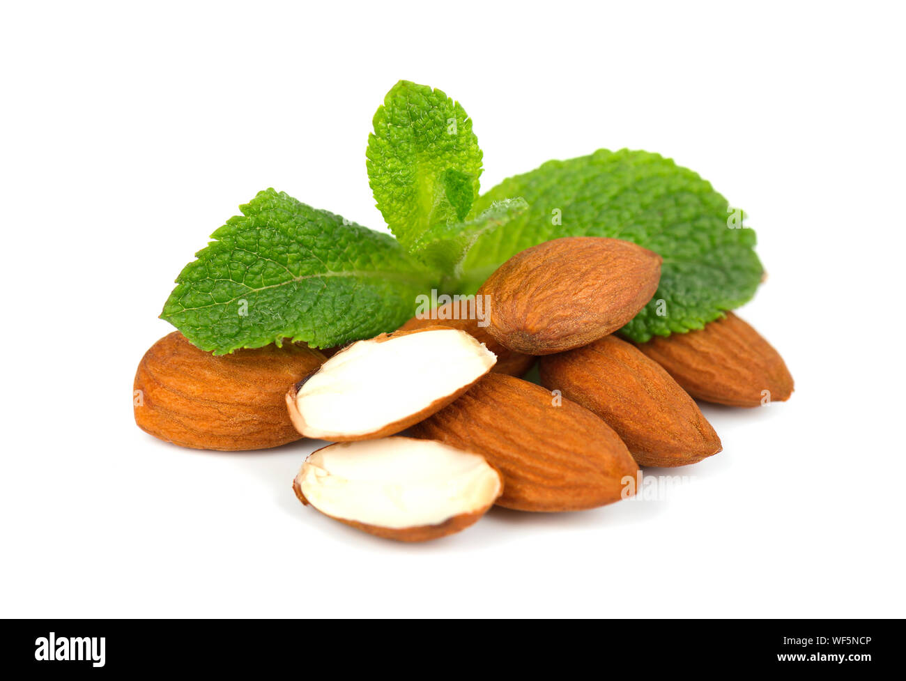 Pile of peeled almonds, with a sprig of mint, isolated on a white ...
