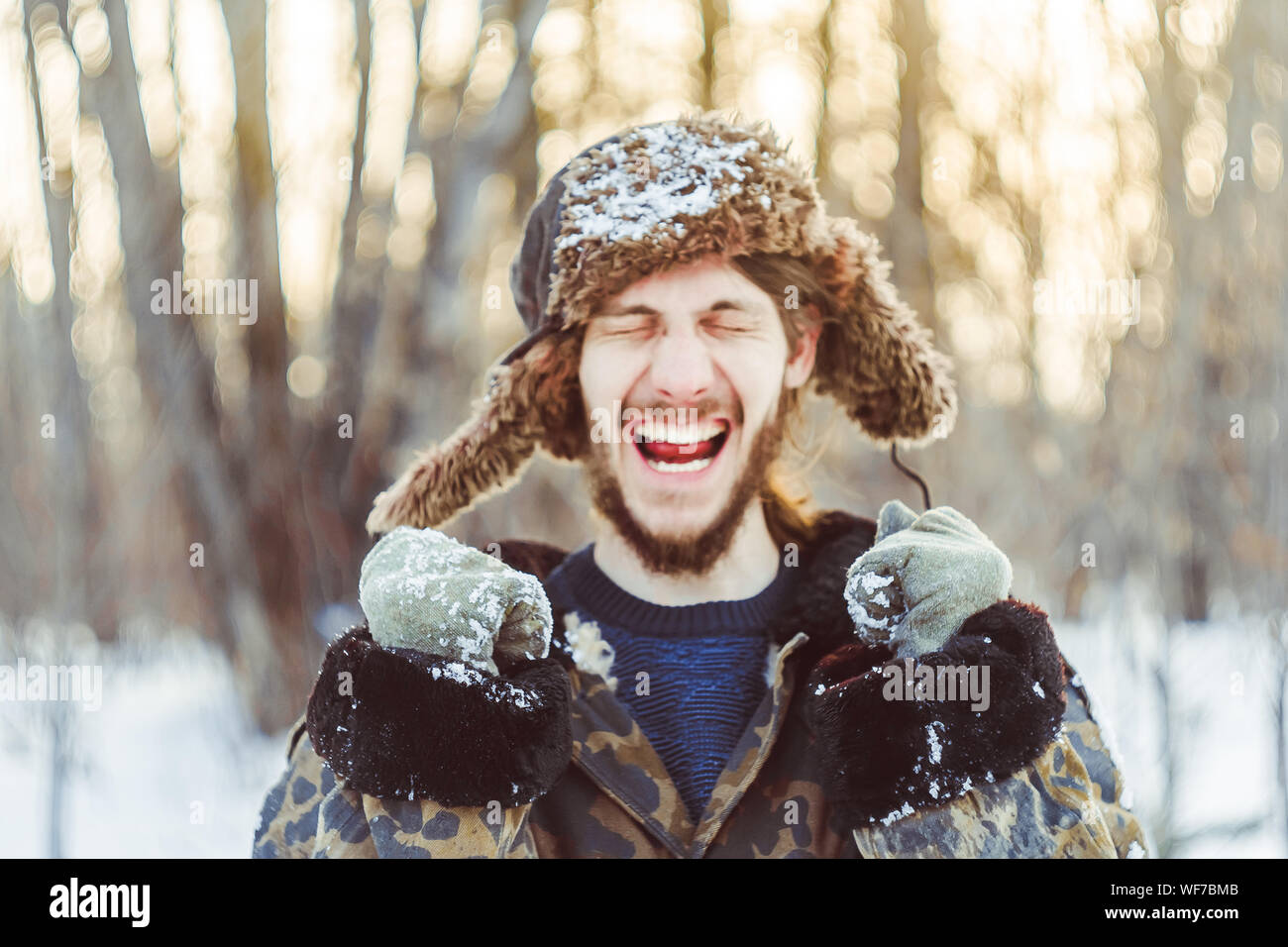 Siberian Russian man in a hat with earflaps rejoices Stock Photo - Alamy