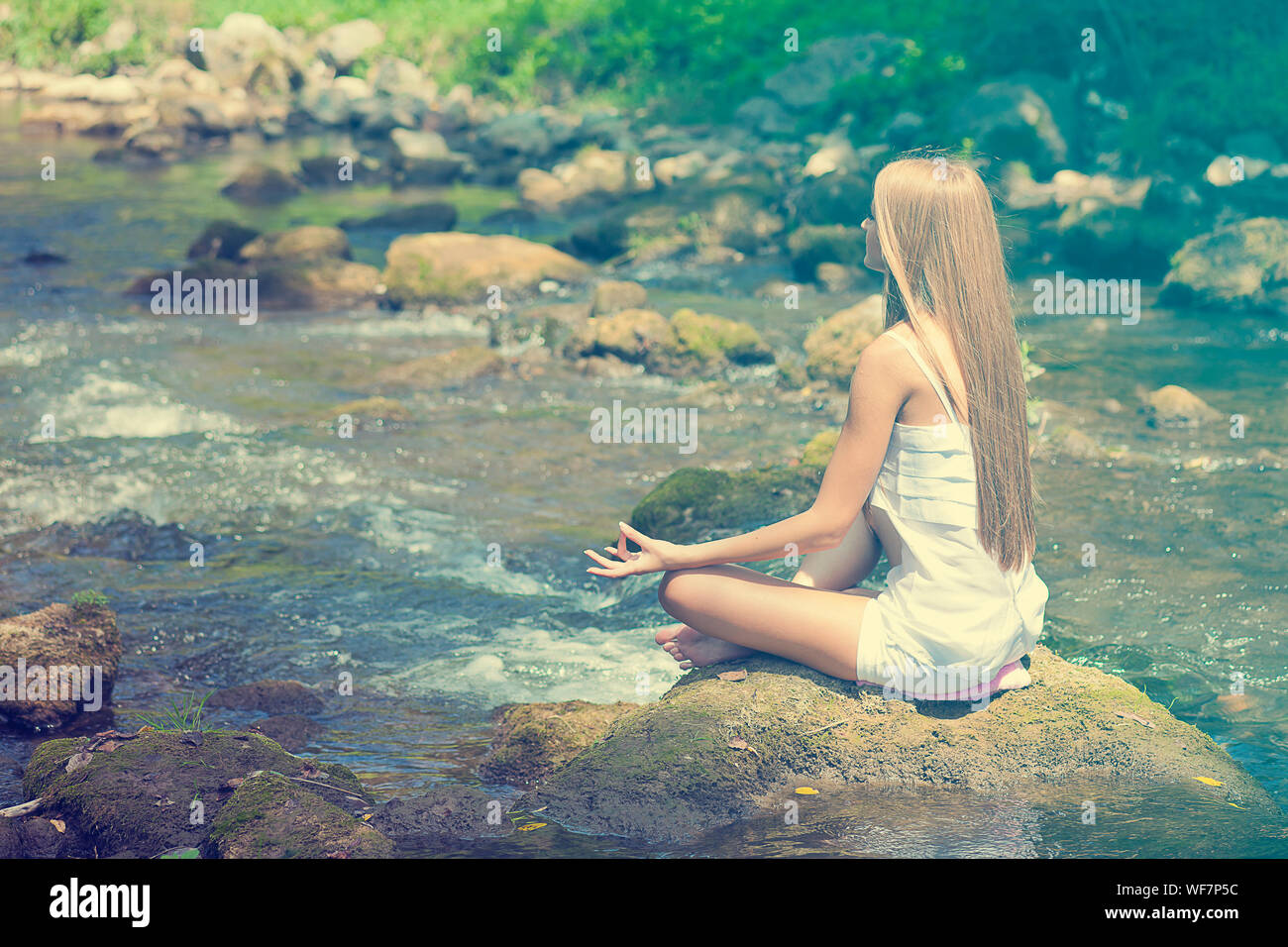 Beautiful woman meditating on rock hi-res stock photography and images ...