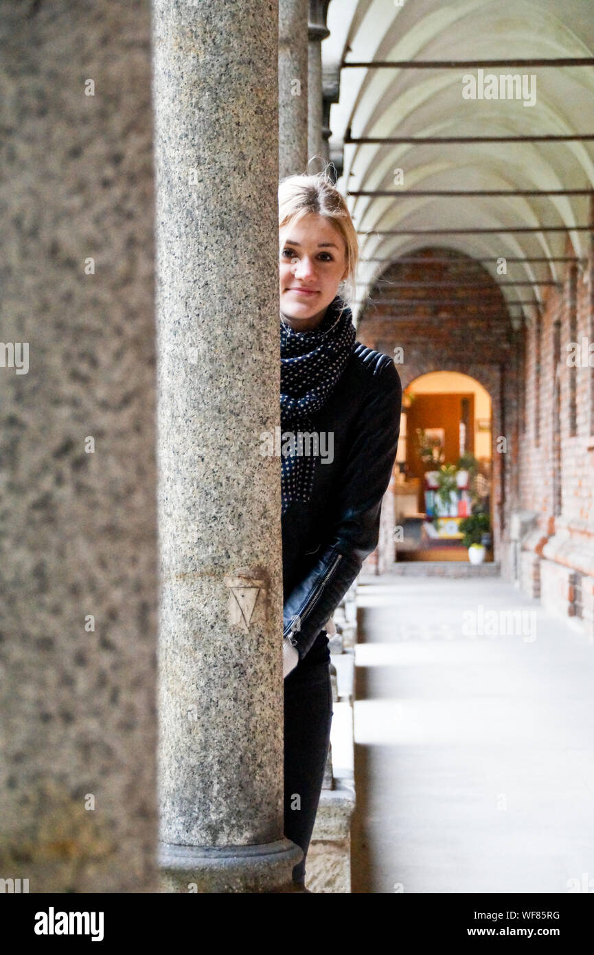 Young woman standing behind column hi-res stock photography and images ...