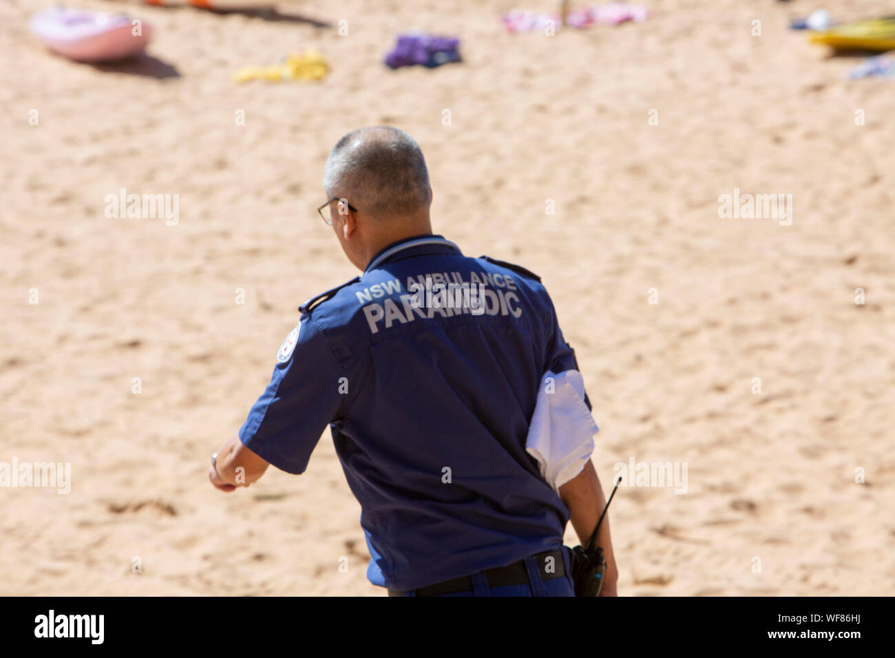 Australian paramedic on the sand at palm beach walking to help injured ...