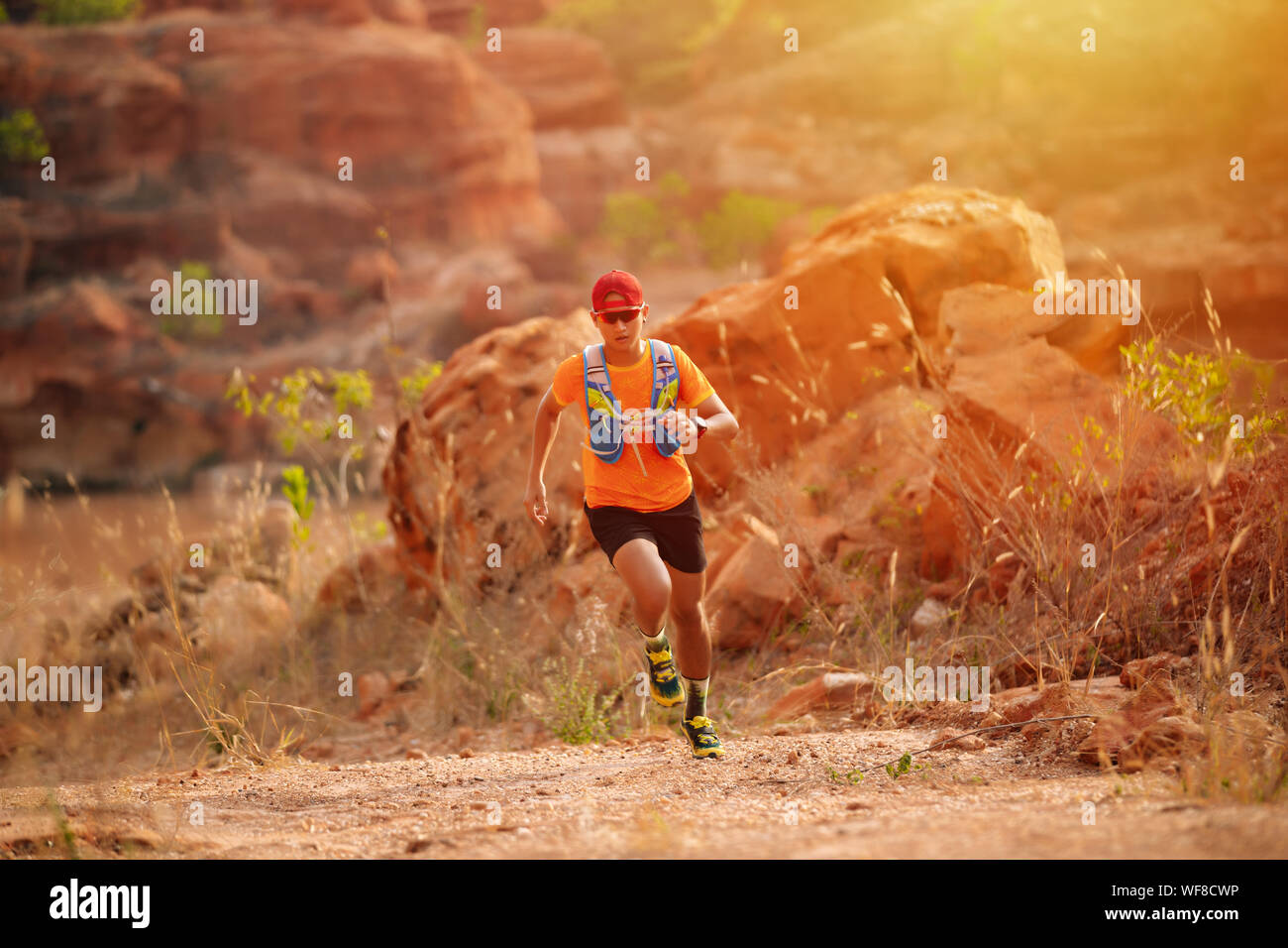 A man Runner of Trail and athlete's feet wearing sports shoes for trail ...