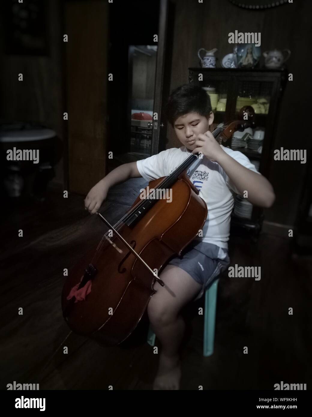 Boy sitting playing instrument hi-res stock photography and images - Alamy