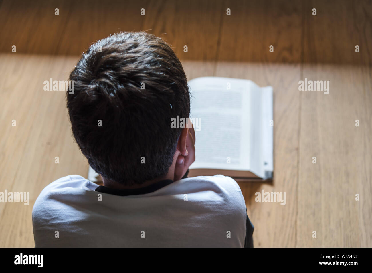 Boy sitting on floor reading book hi-res stock photography and images ...