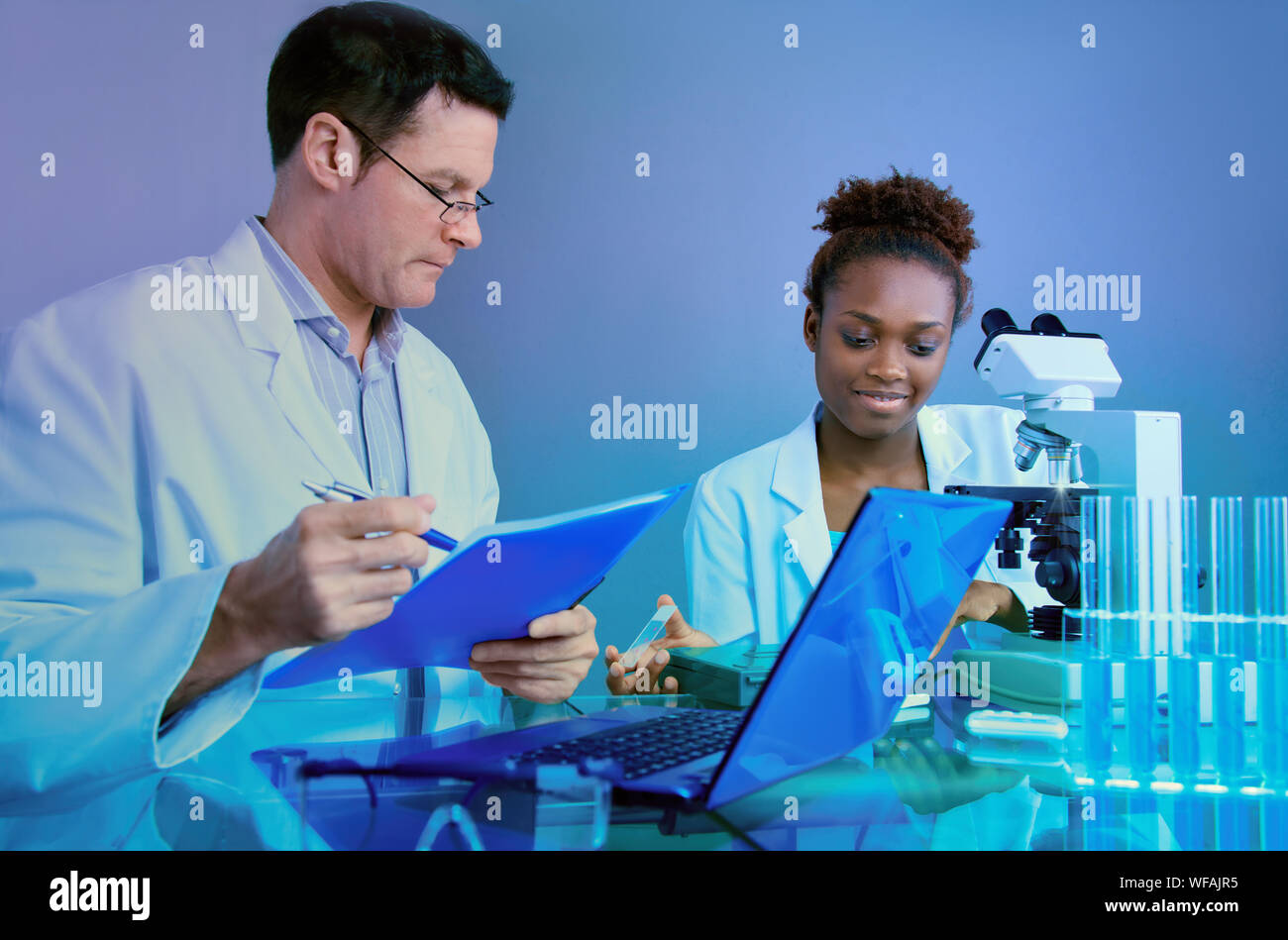 Scientists, senior Caucasian male and young African female, work ...