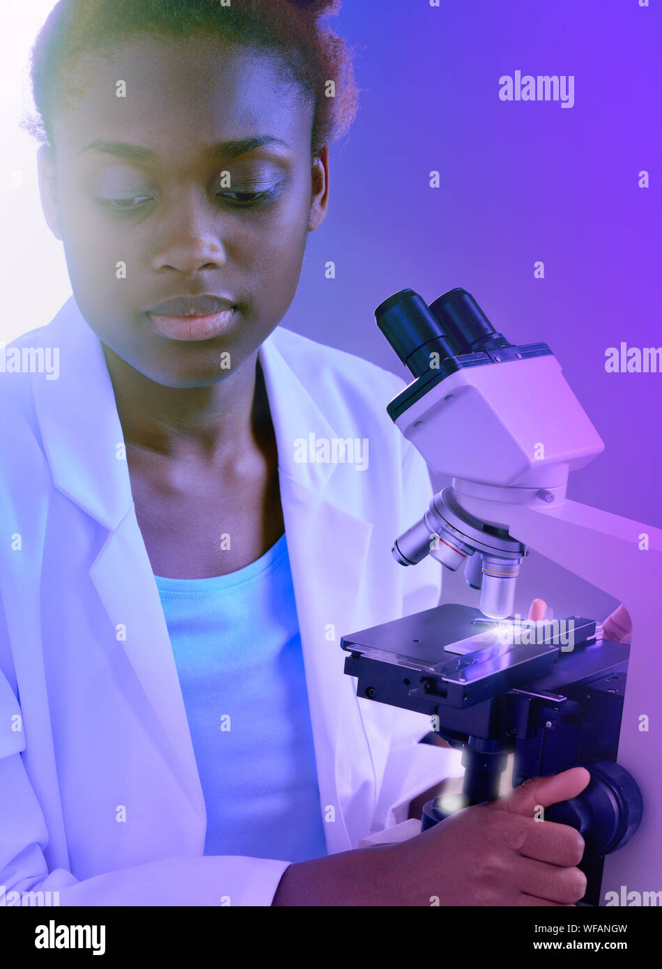 African scientist or graduate student in lab coat working with modern ...