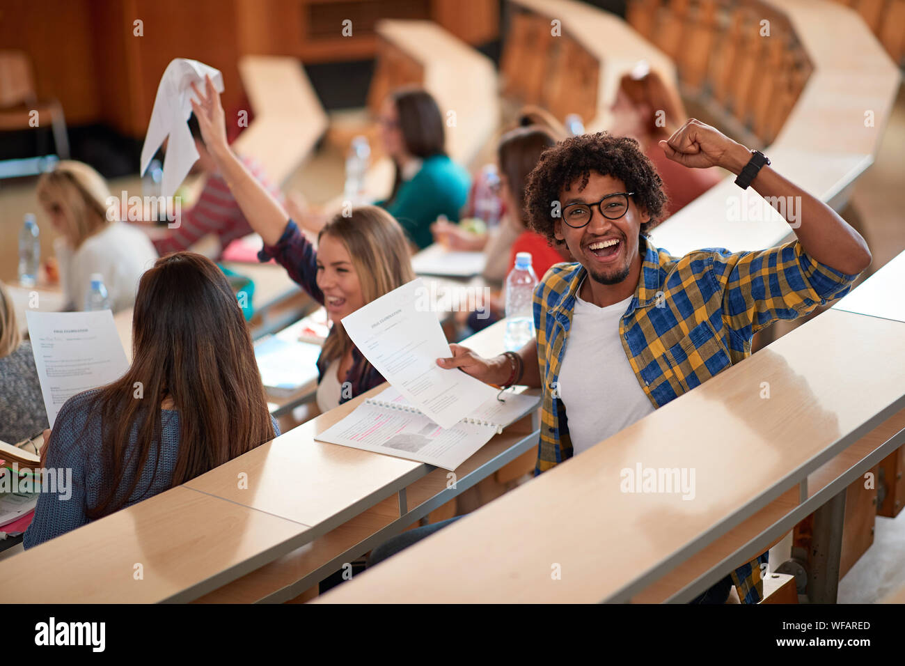 successful final examination – young students having a test in a ...