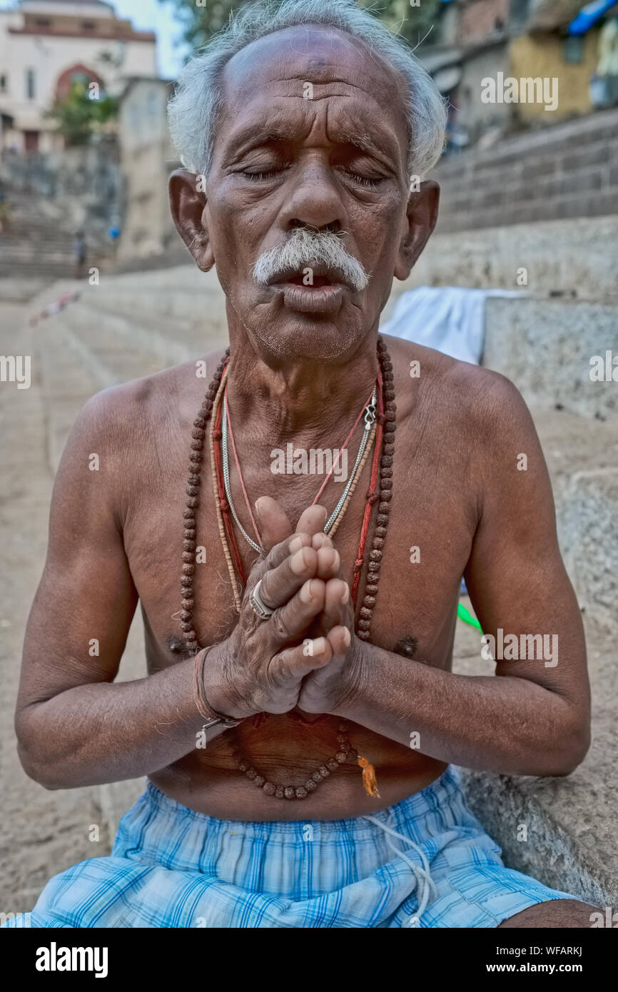 A Hindu man wearing holy Rudraksha beads praying and meditating at ...