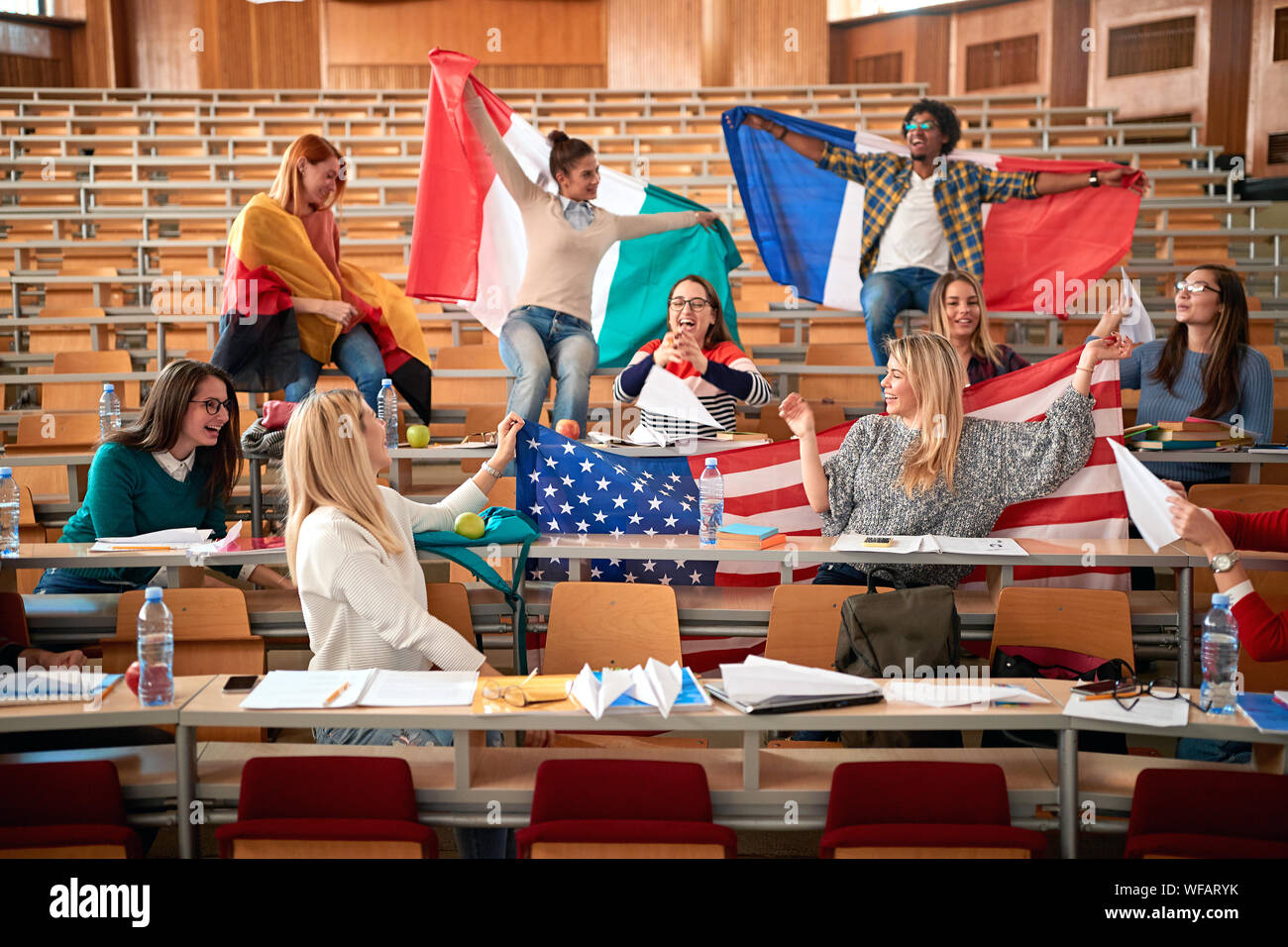 Young happy students present country with flag on university campus ...