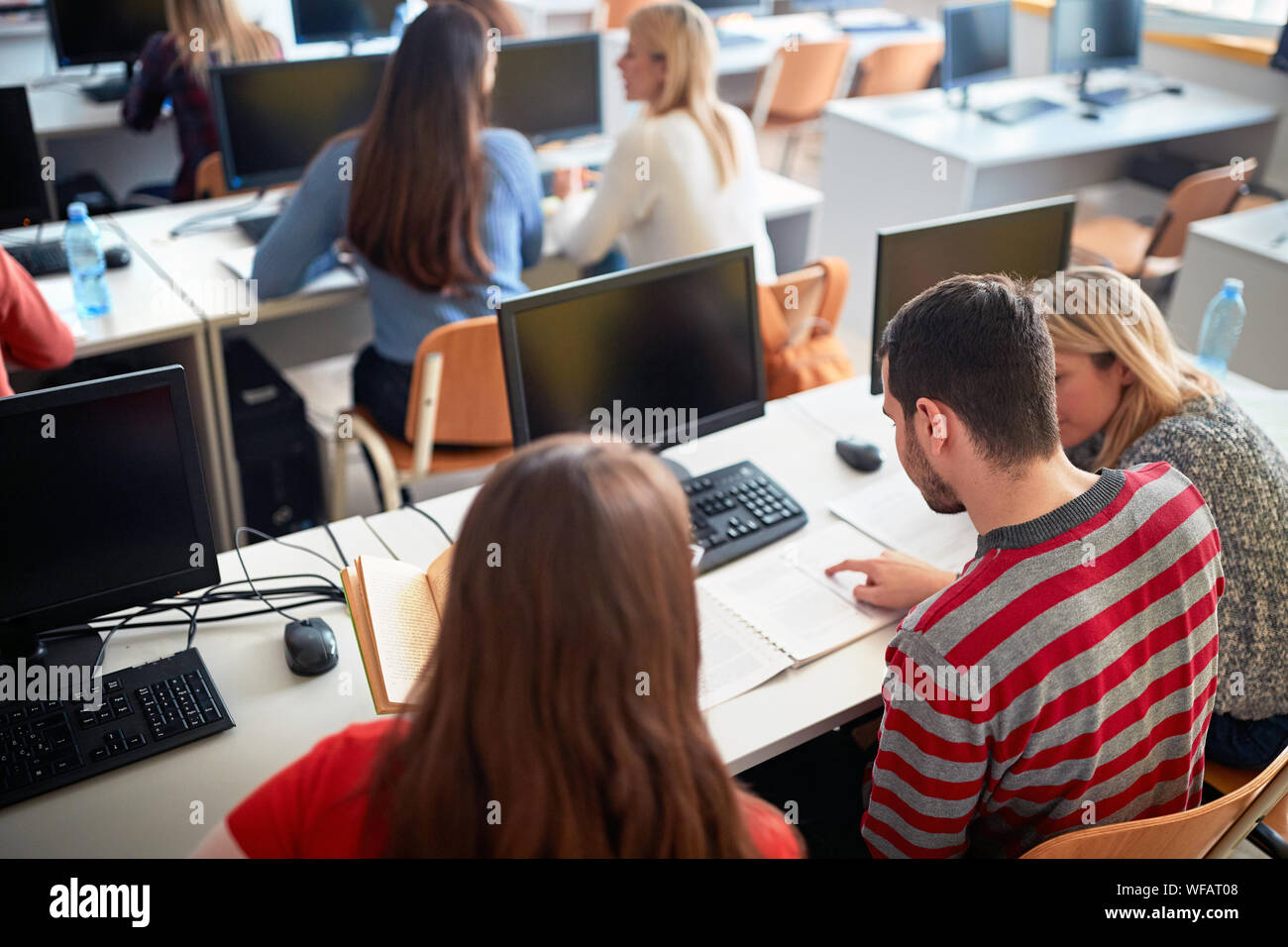 young students studying on university campus using computer in class ...