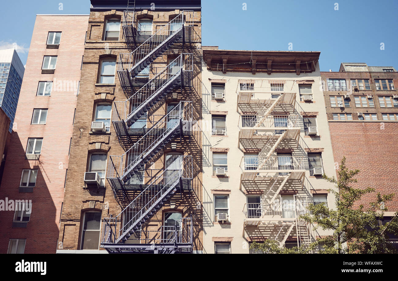 Retro toned picture of old buildings with fire escapes, New York City ...