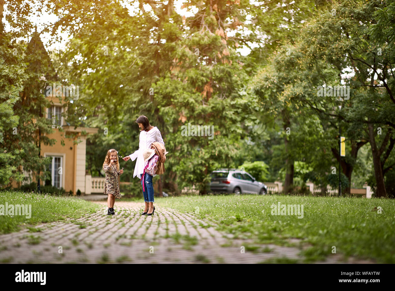 Mother and cute girl going home from school Stock Photo - Alamy