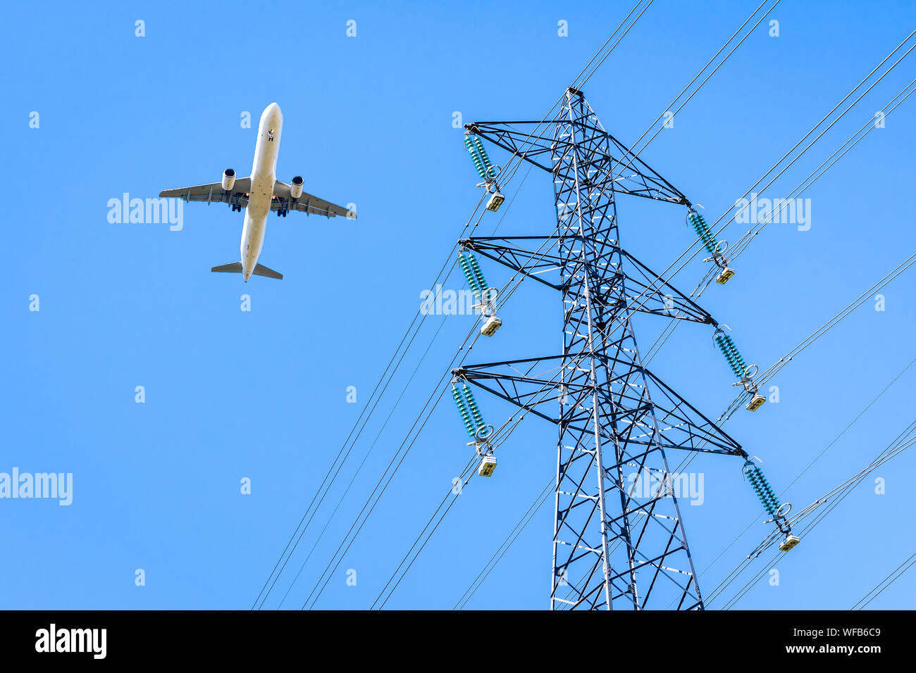 View from below of an airliner in landing approach flying over a high ...