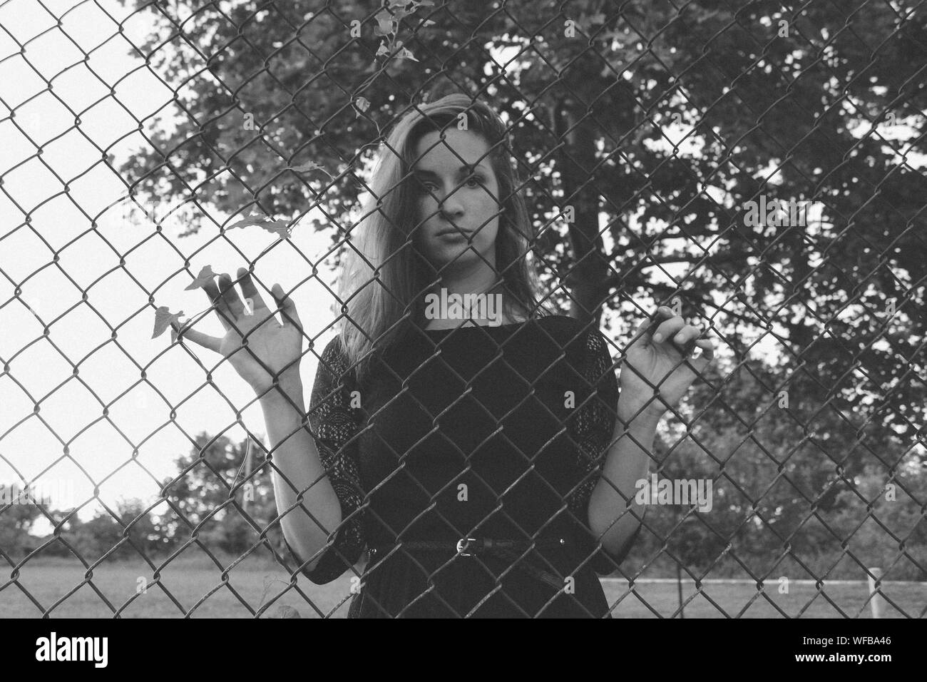 Portrait Of Woman Behind Chainlink Fence Stock Photo - Alamy