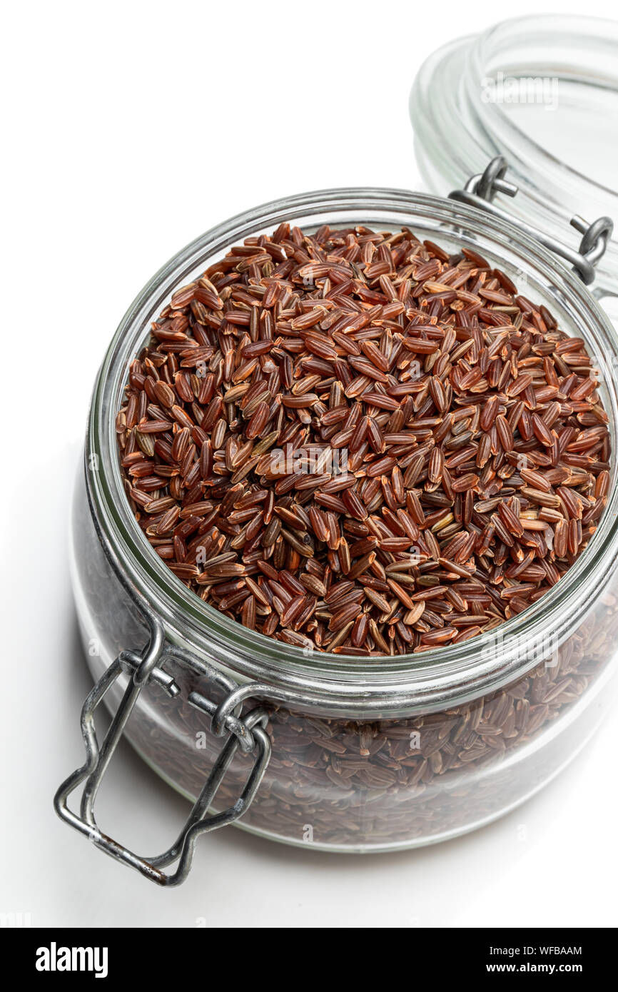 Red rice in wooden bowl isolated on white Stock Photo - Alamy