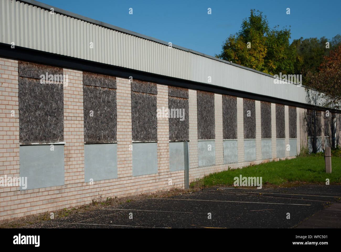 Row of boarded-up windows on a disused factory building Stock Photo - Alamy