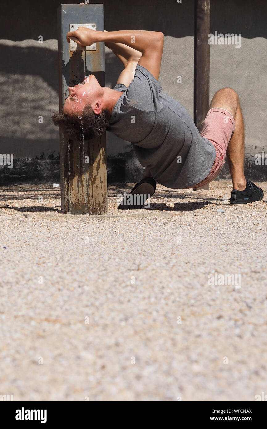 Young Man Drinking Water From Faucet On Street Stock Photo - Alamy