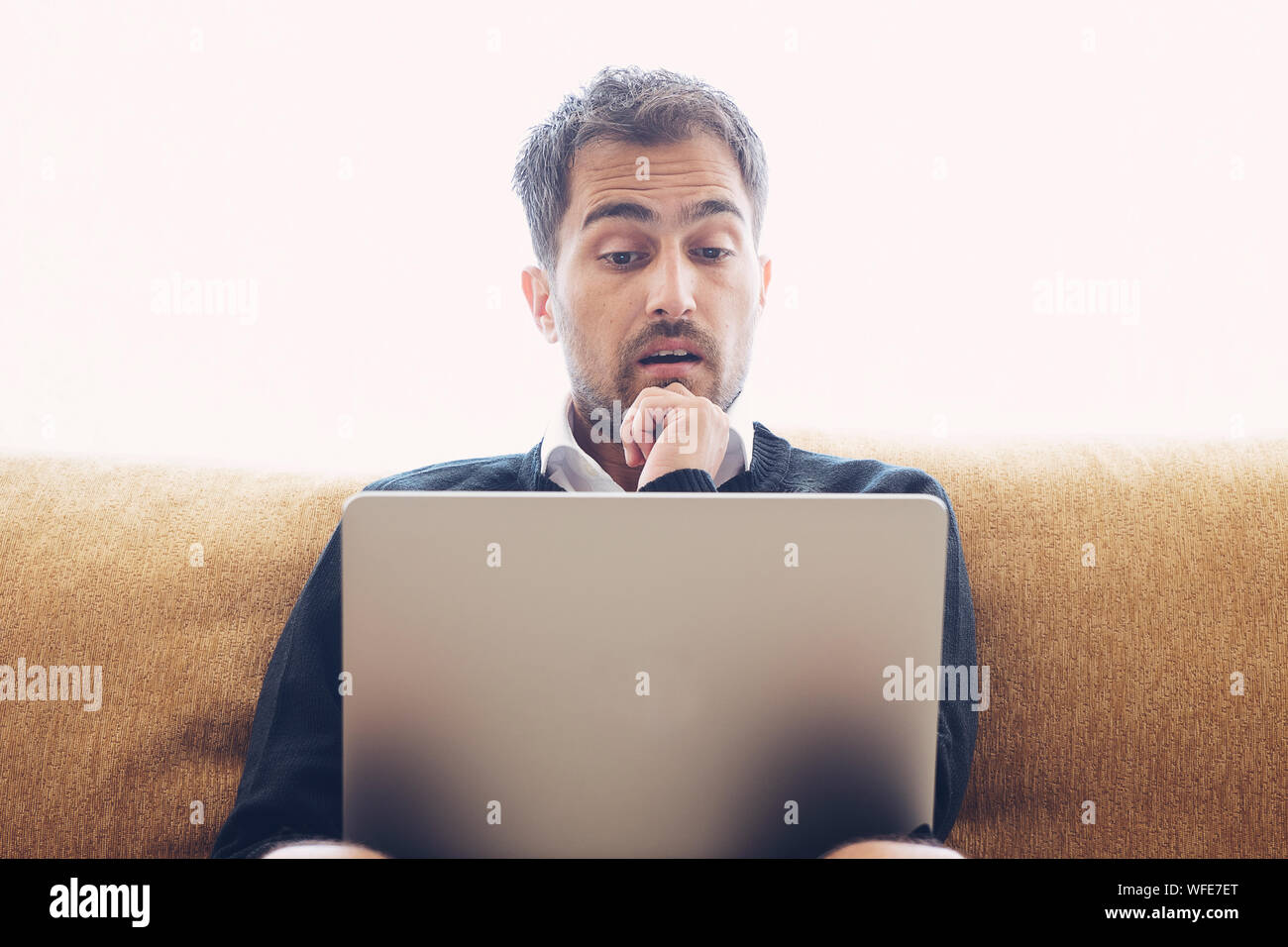 Confused surprised young man using a pc laptop computer Stock Photo - Alamy